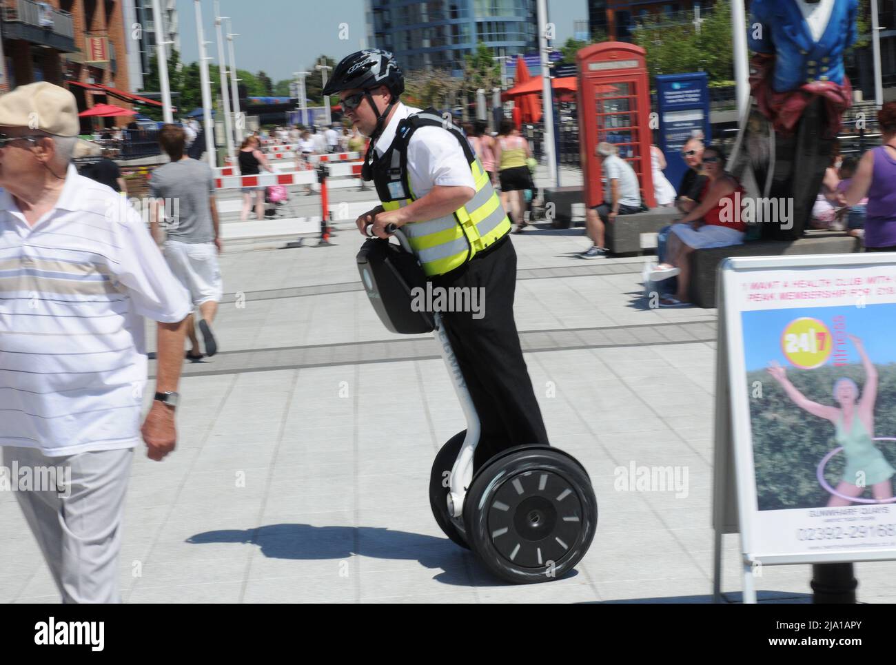 A COMMUNITY POLICE OFFICER ON PATROL RIDING A SEGWAY AT GUNWHARF QUAYS ...