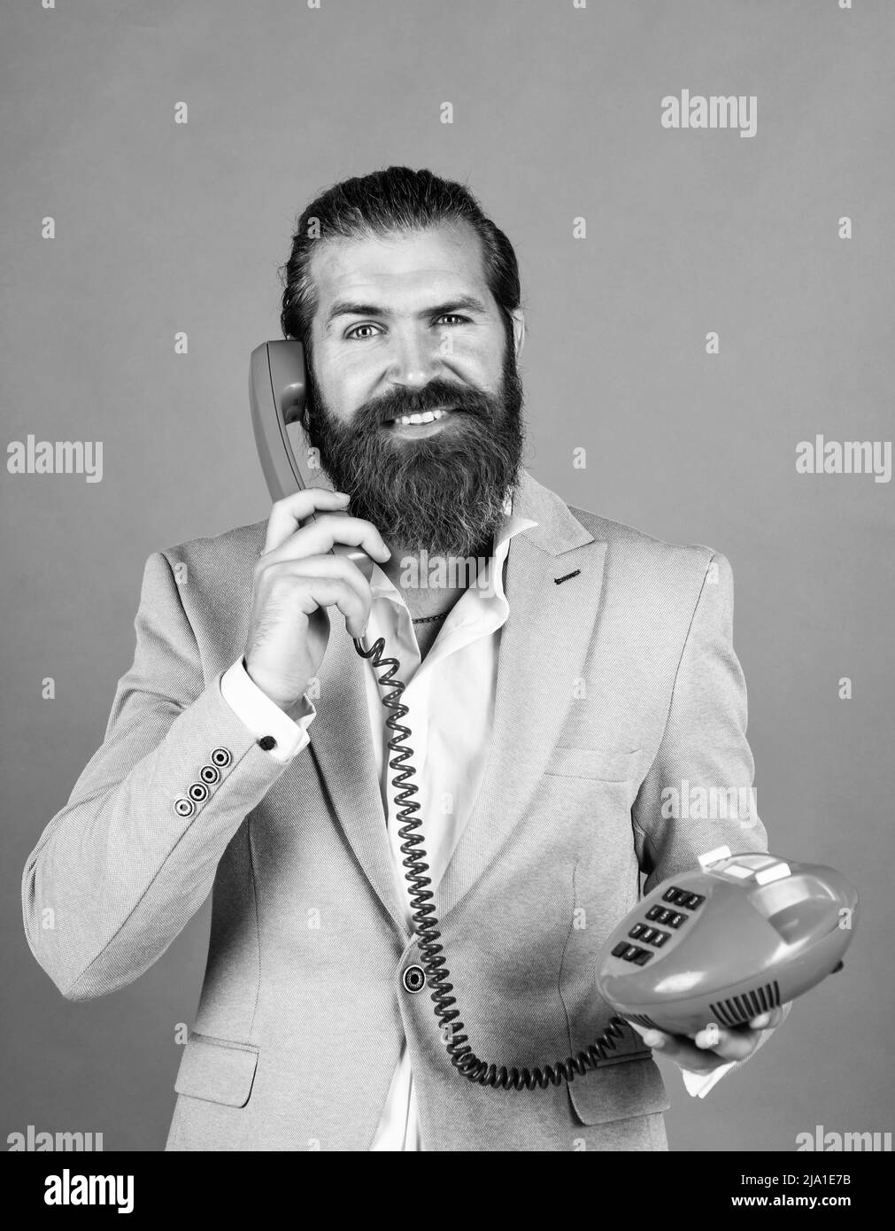 happy man with retro phone. brutal bearded man hold vintage telephone ...