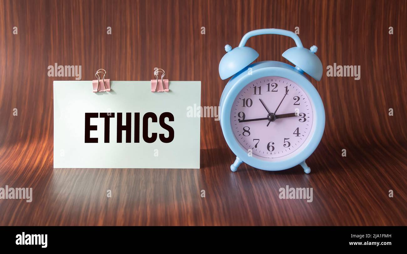 Abstract word ETHICS on notepad and wooden background with clock Stock ...