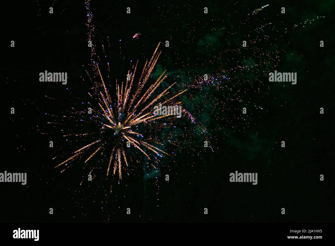 Beautiful festive yellow fireworks, with haze, in the night sky. High ...