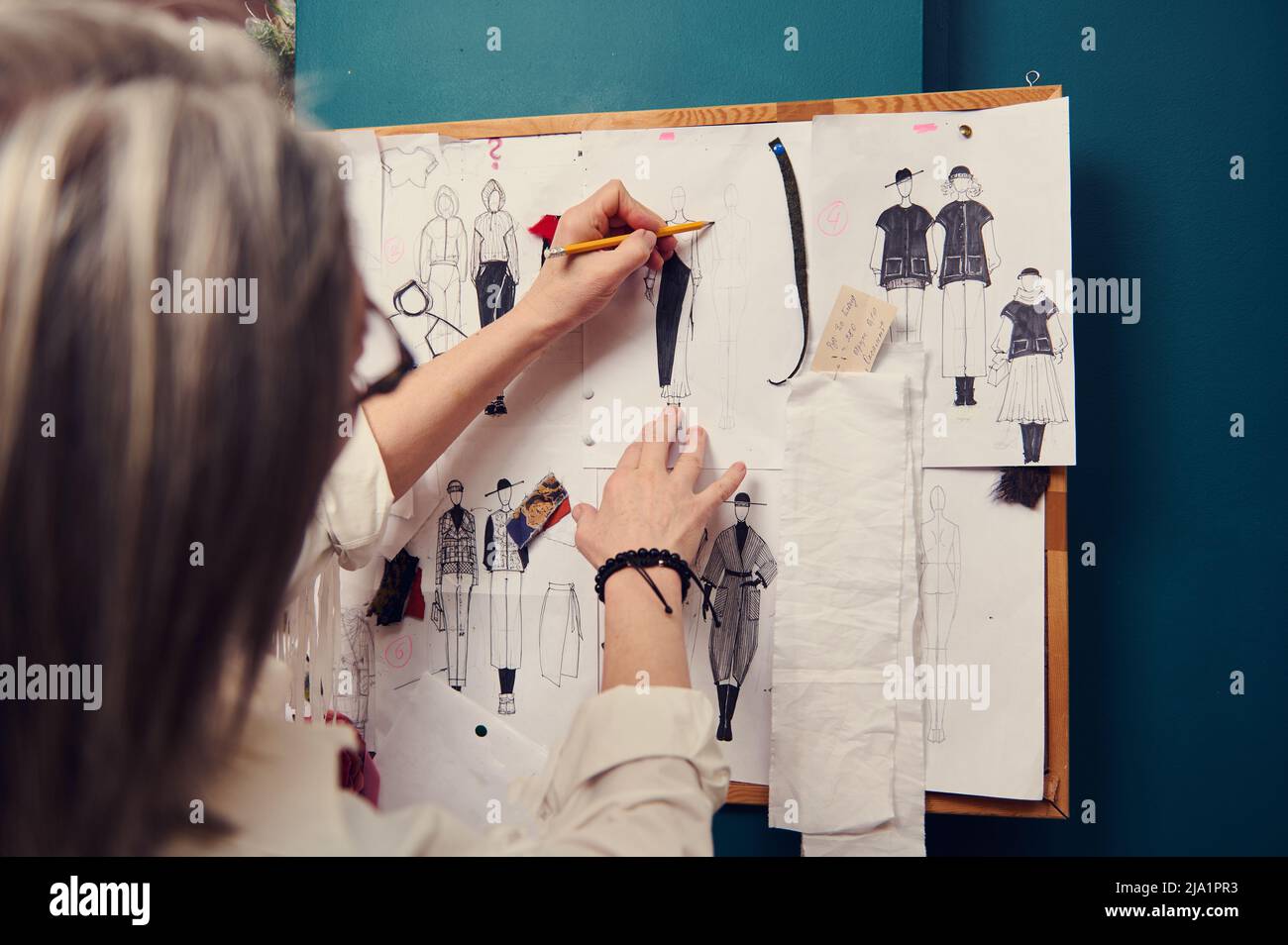 Close-up of the fashion designer's hands holding pencil and sketching ...
