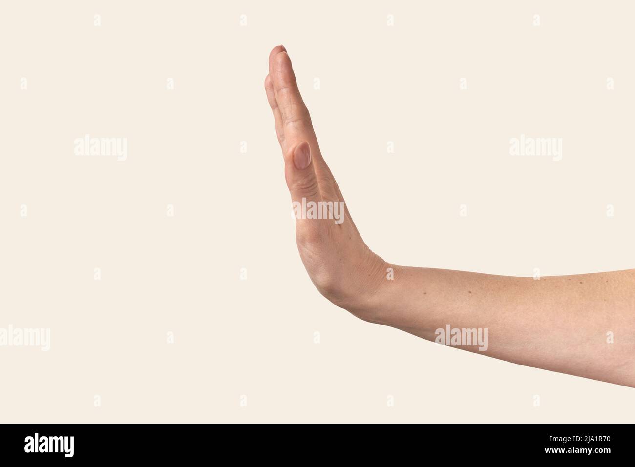 Female hand stop gesture on beige Stock Photo - Alamy