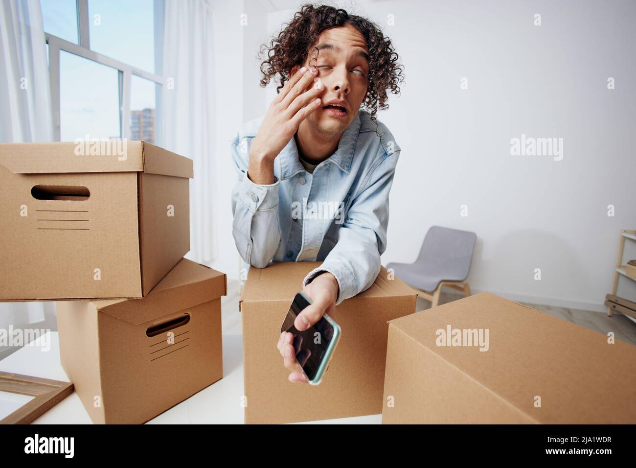 A young man unpacking things from boxes in the room interior Stock ...