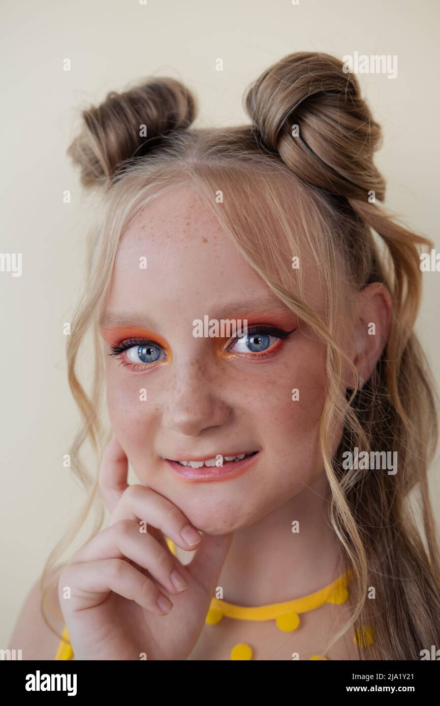 charming blonde tween girl with orange makeup on yellow background. teenager portrait Stock ...