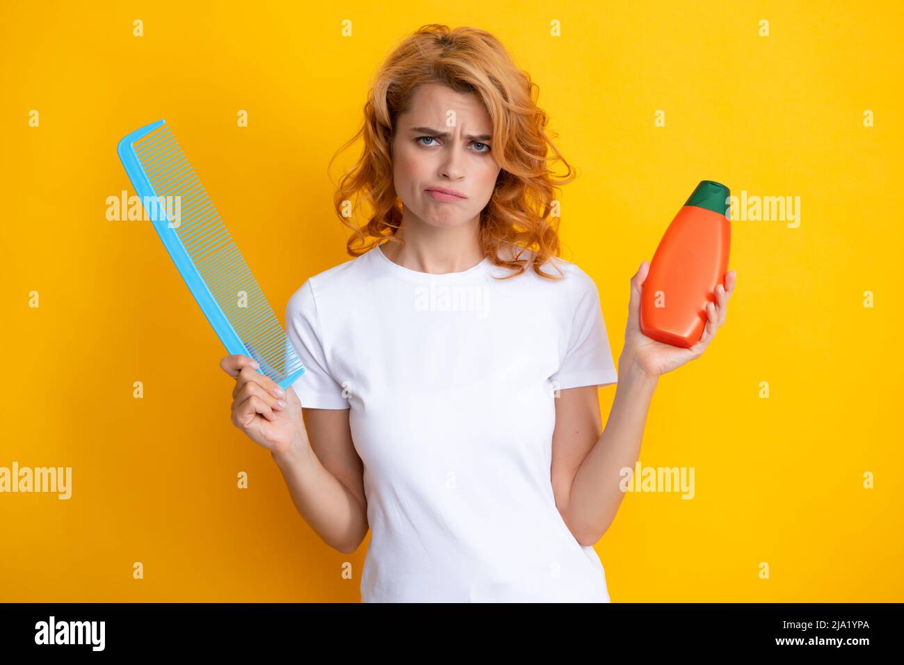 Angry sad woman hairdresser with comb. Funny woman hold bottle shampoo ...