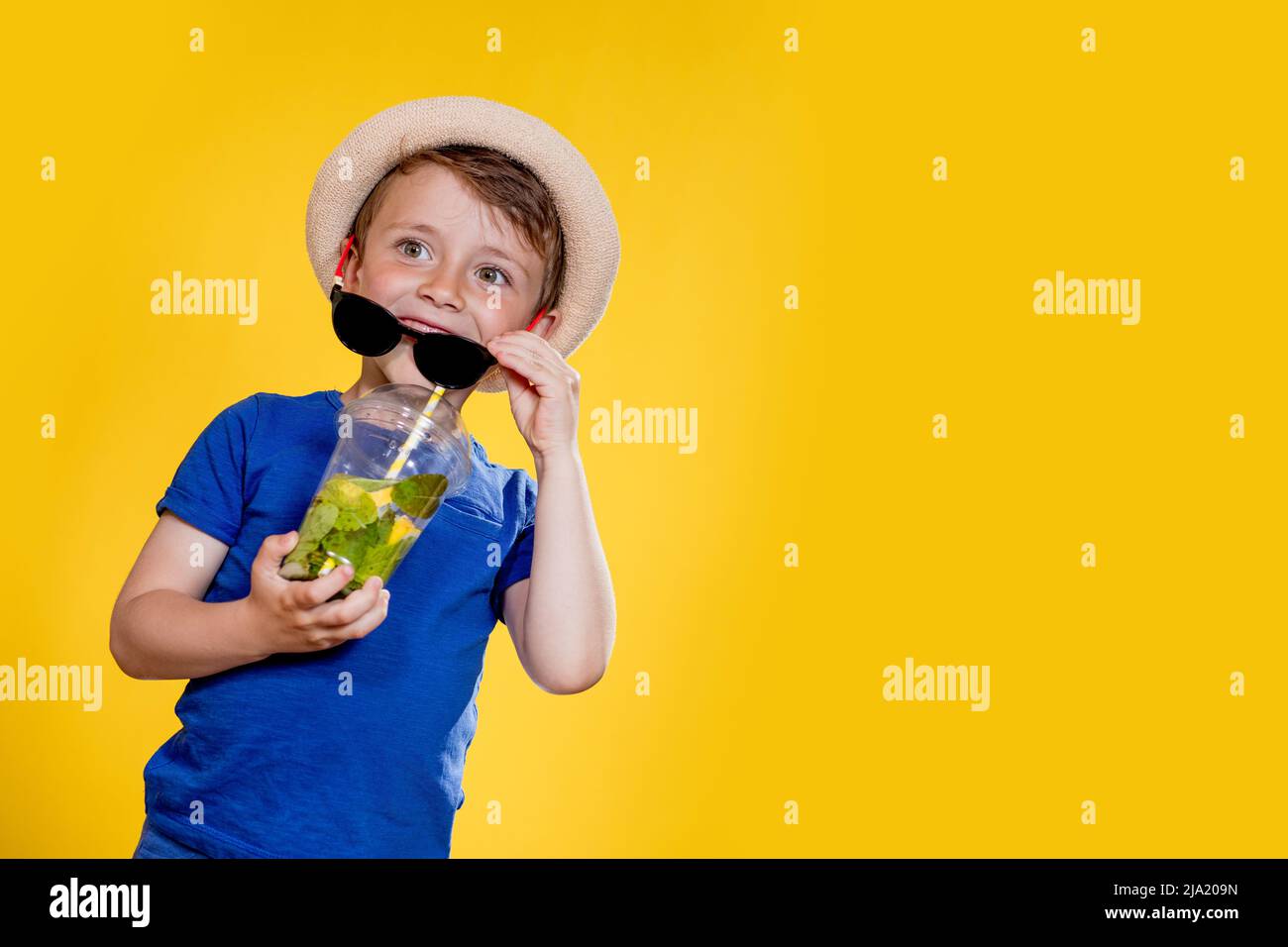 Boy in summer outfit wearing sunglasses and enjoying while drinking a ...