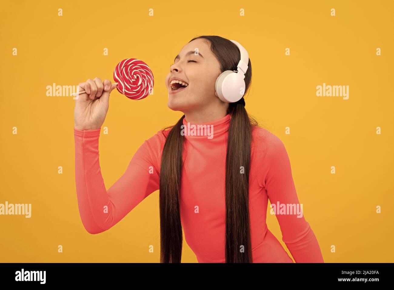 happy kid singer listen music in headphones singing with lollypop on ...