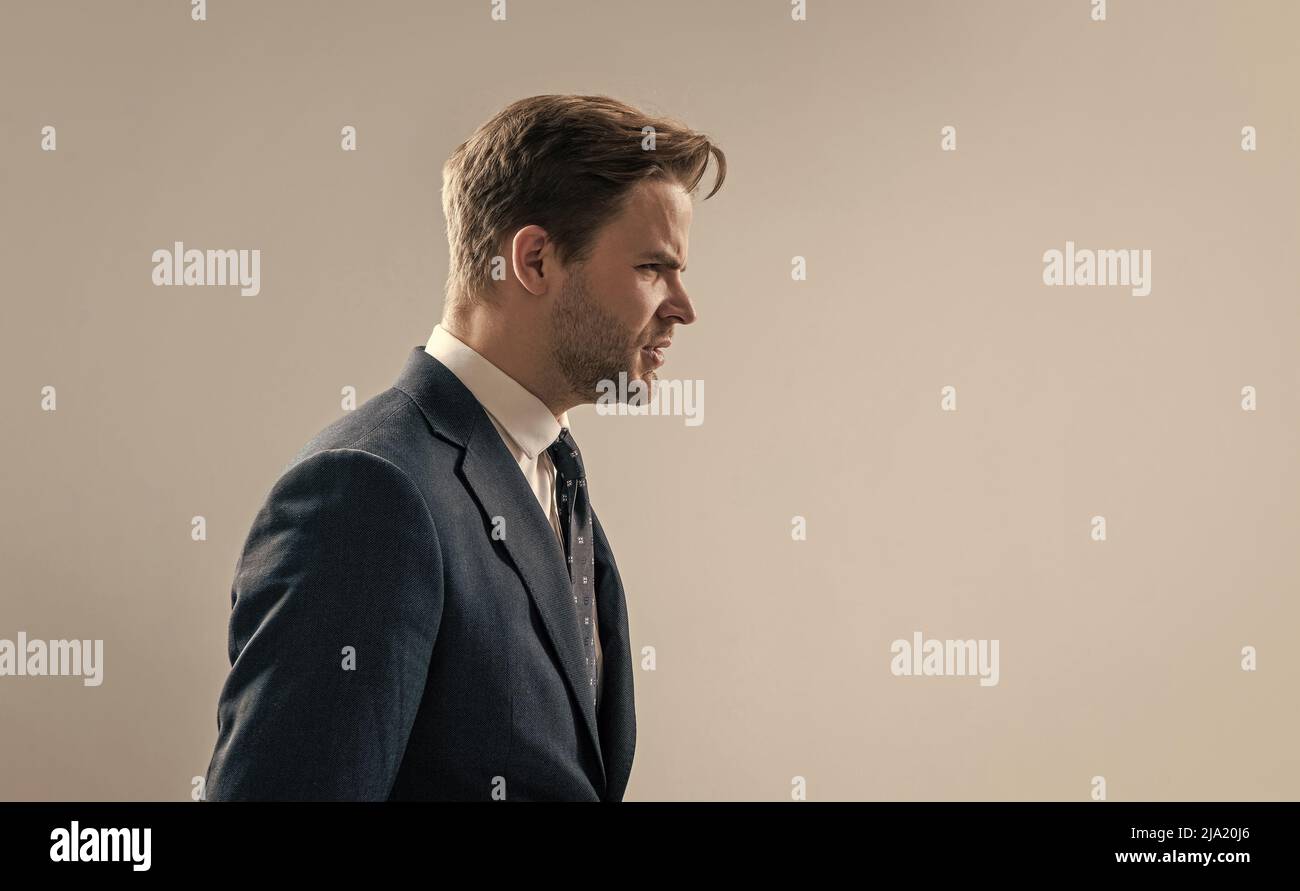 Angry business professional man stand sideway in anger grey background ...