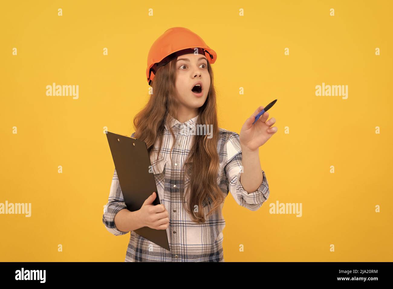 shocked teen girl in helmet and checkered shirt making notes on ...