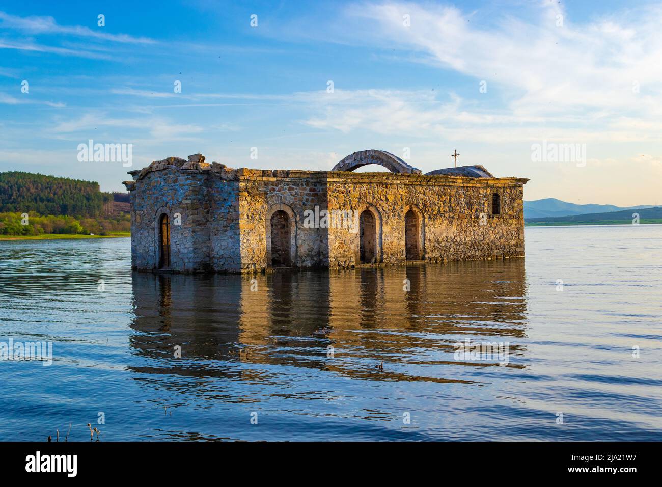 Sunset sky over the sunken church of St.Ivan Rilski at Zhrebchevo Dam ...