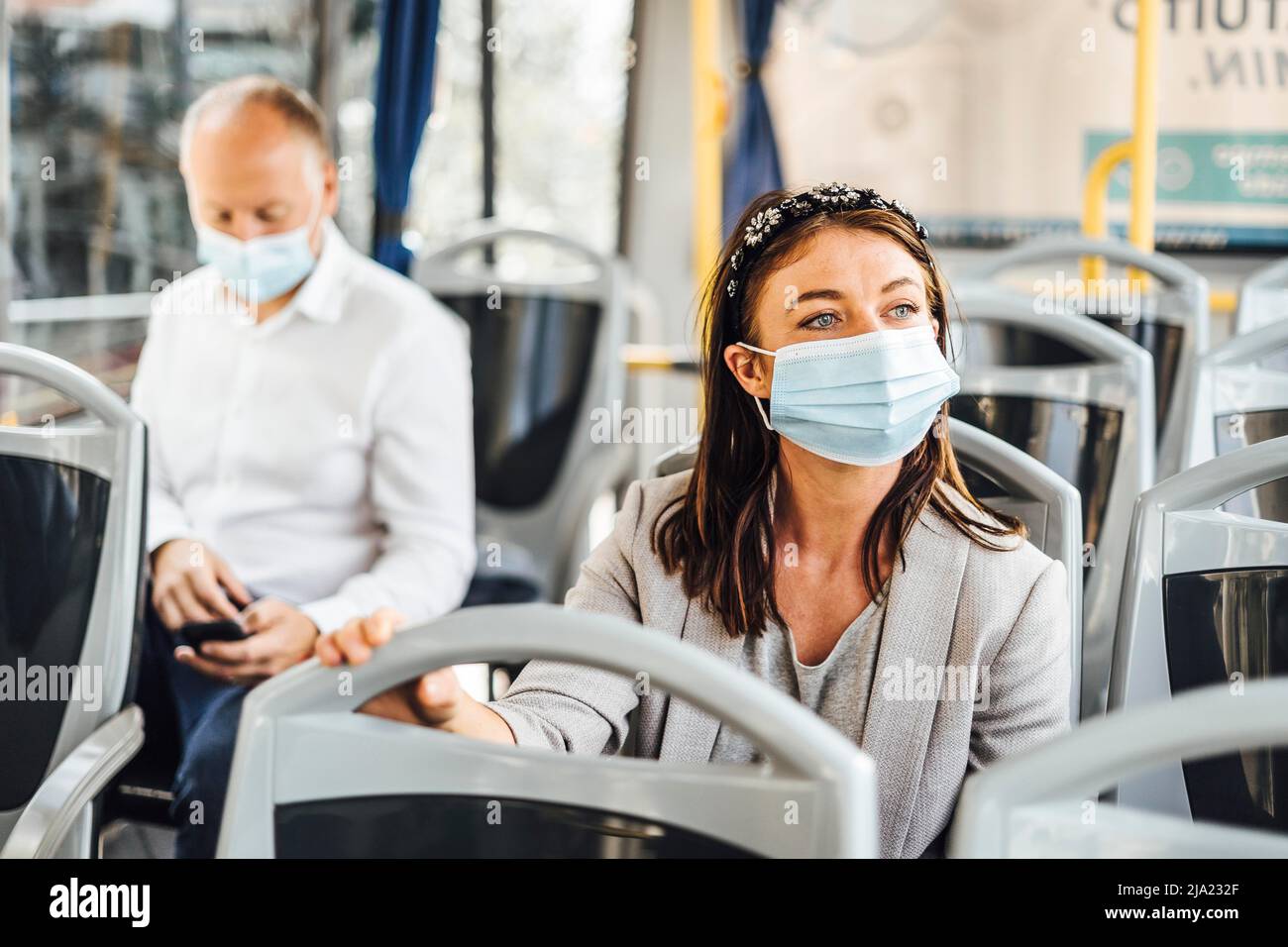 Travelers wearing protective masks commuting by public bus Stock Photo ...
