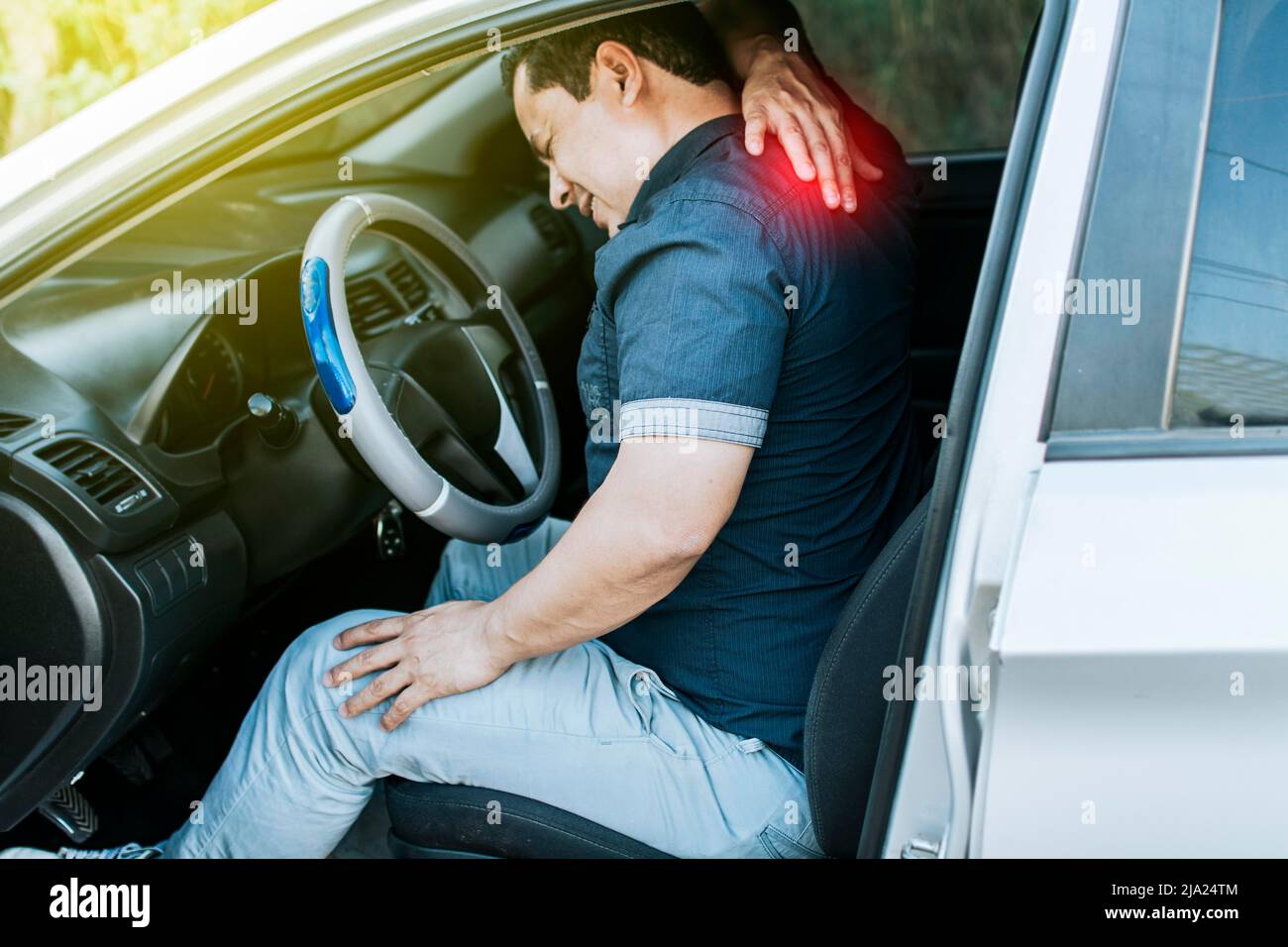 A car driver with muscle pain, concept of a man in his car with neck ...