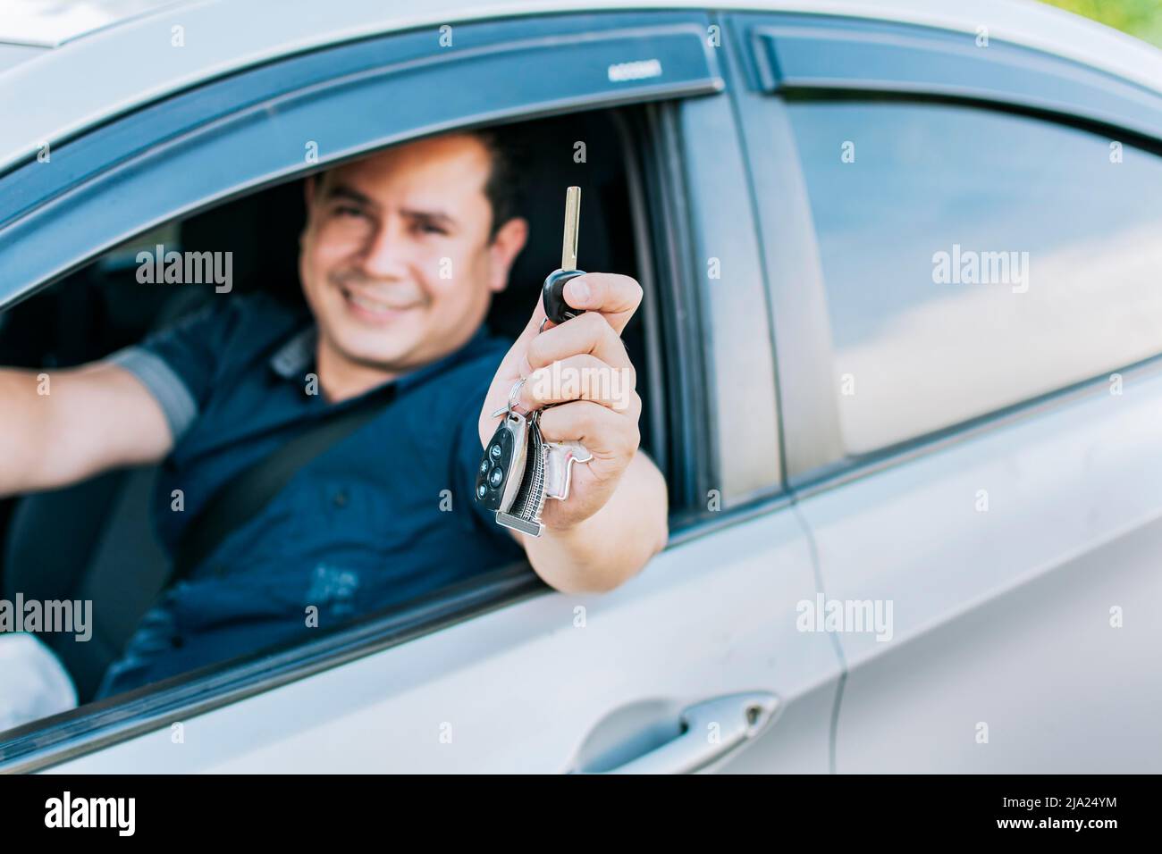 A man in his vehicle showing his new car keys, a happy guy showing the ...