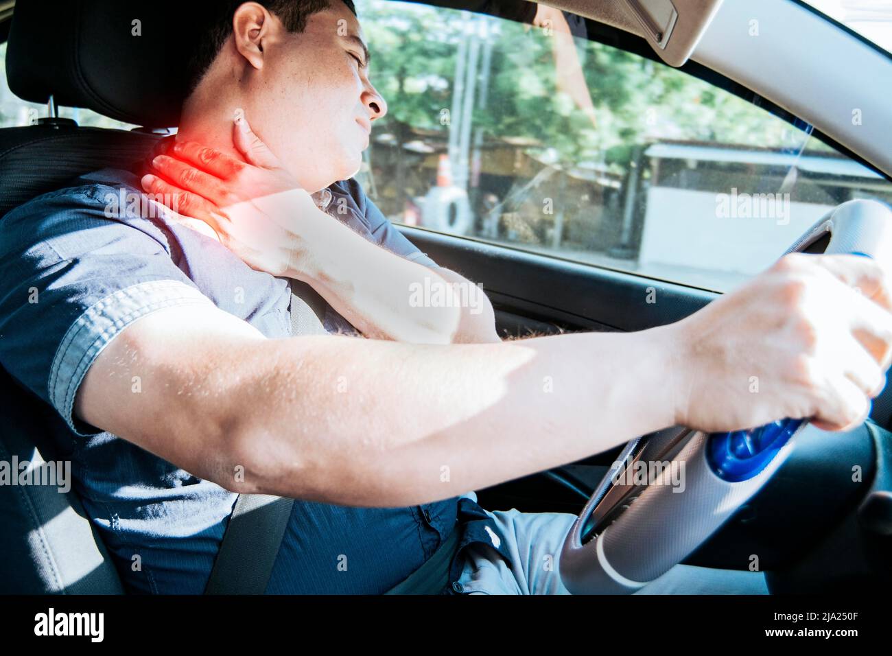 A driver with neck pain, concept of a man in his car with neck pain. An ...