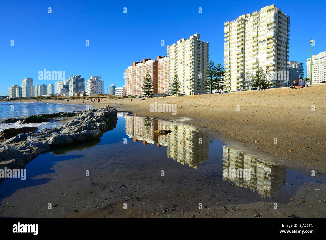 High-rise buildings with flats reflected in the water on the beach ...