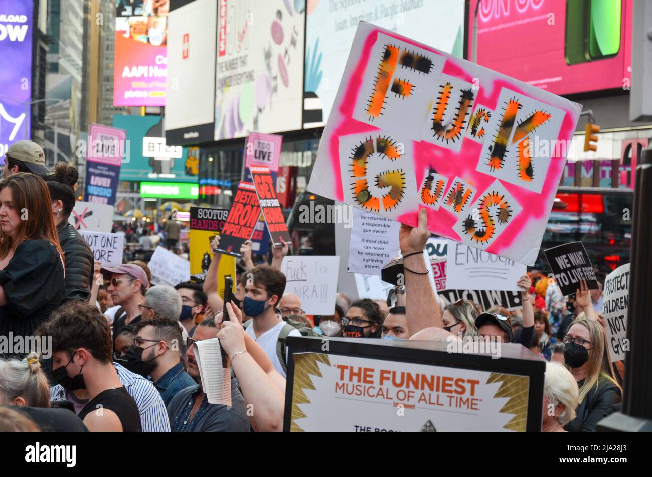 March participants are seen holding signs at Times Square, New York ...