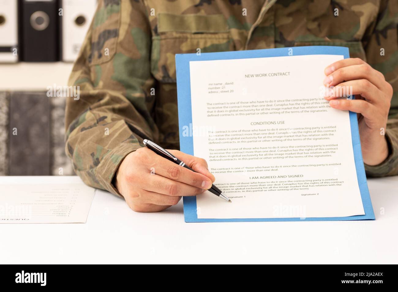 Close up of military man hands showing and pointing contract signature ...