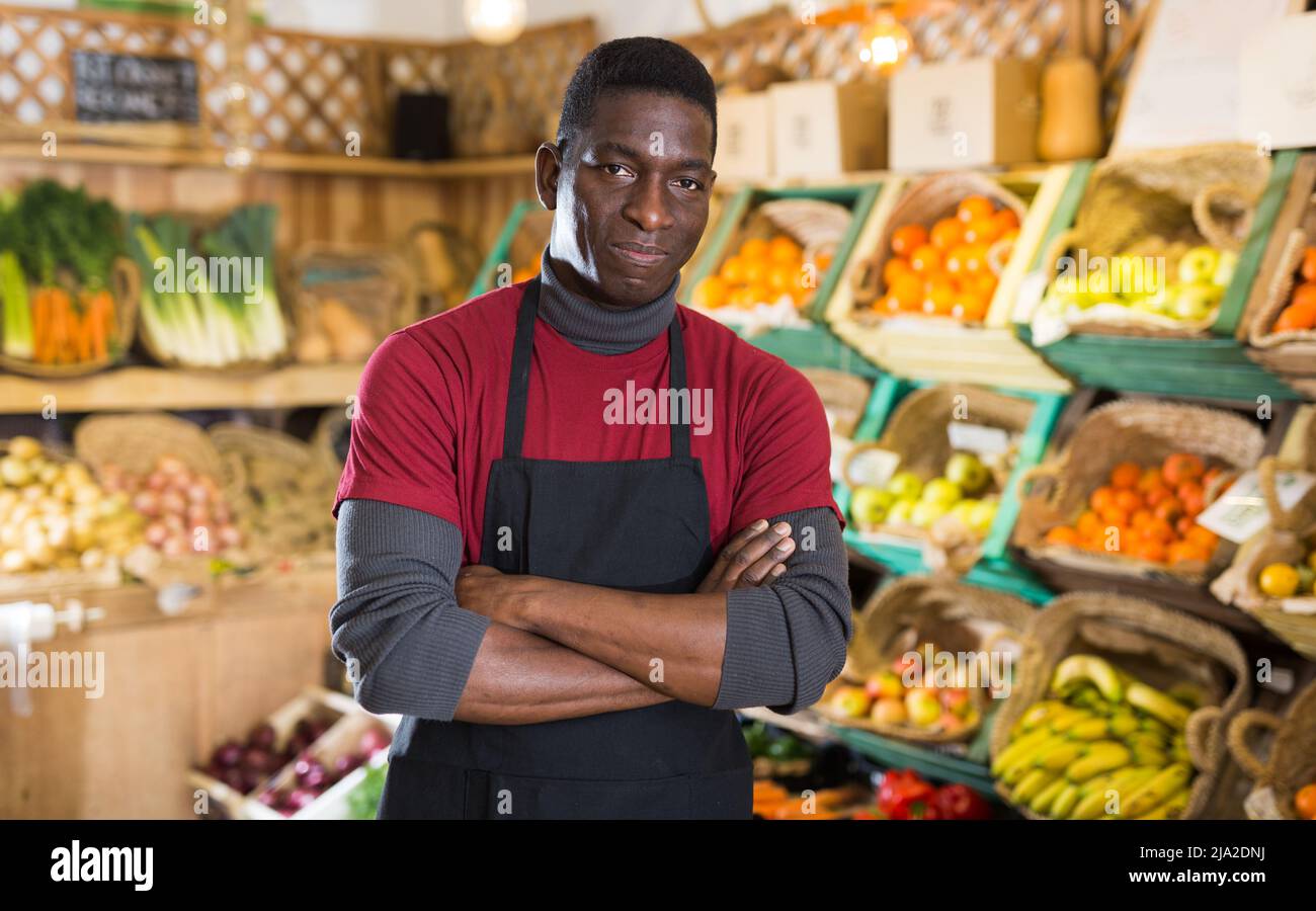 Confident salesman of fruit and vegetable store Stock Photo - Alamy