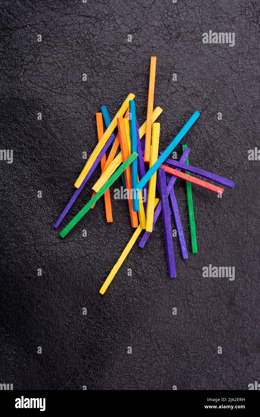 Beautiful coloured wooden sticks for creativity on black background ...