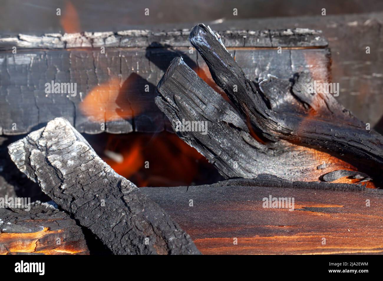 a fire made of logs with a bright flame at a camping while cooking, a ...