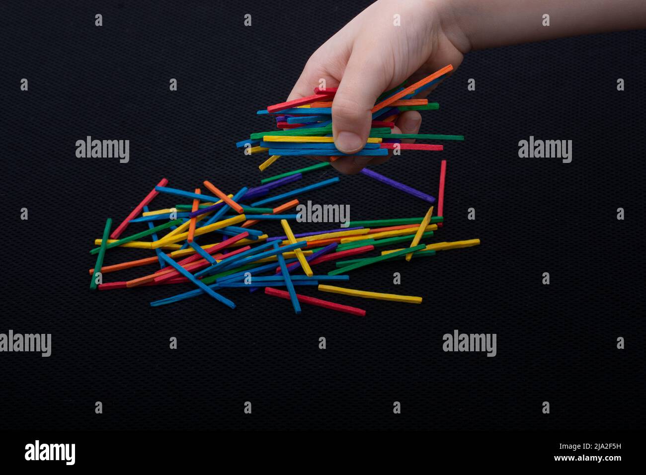 Beautiful coloured wooden sticks for creativity on black background ...