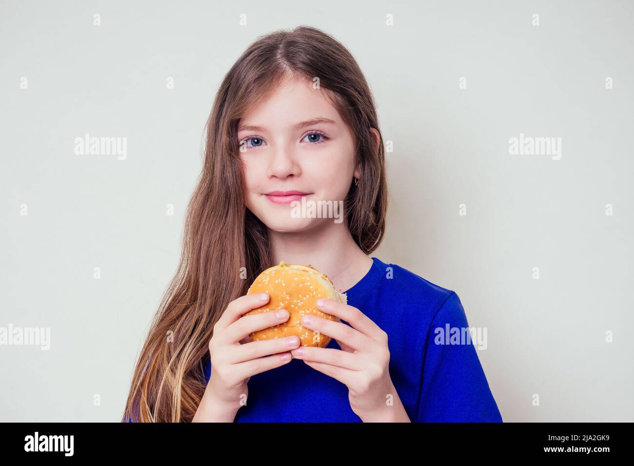 beautiful teenager girl is eating baked vegetarian burger with ...