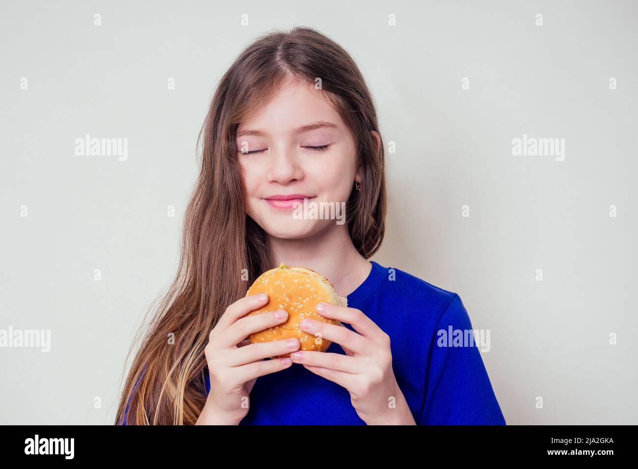 beautiful teenager girl is eating baked vegetarian burger with ...