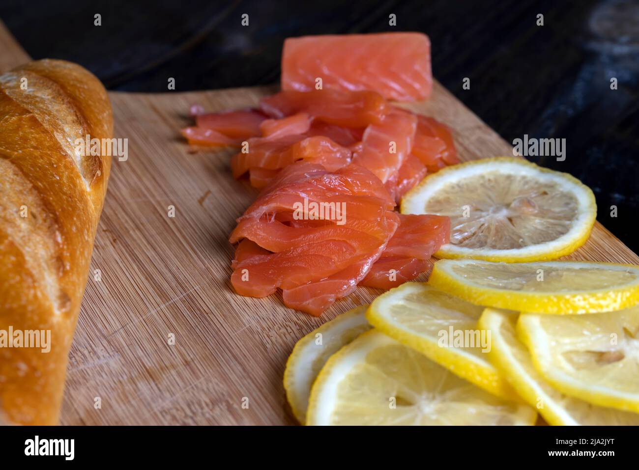 sliced red salted salmon during cooking, cutting fish fillets during ...
