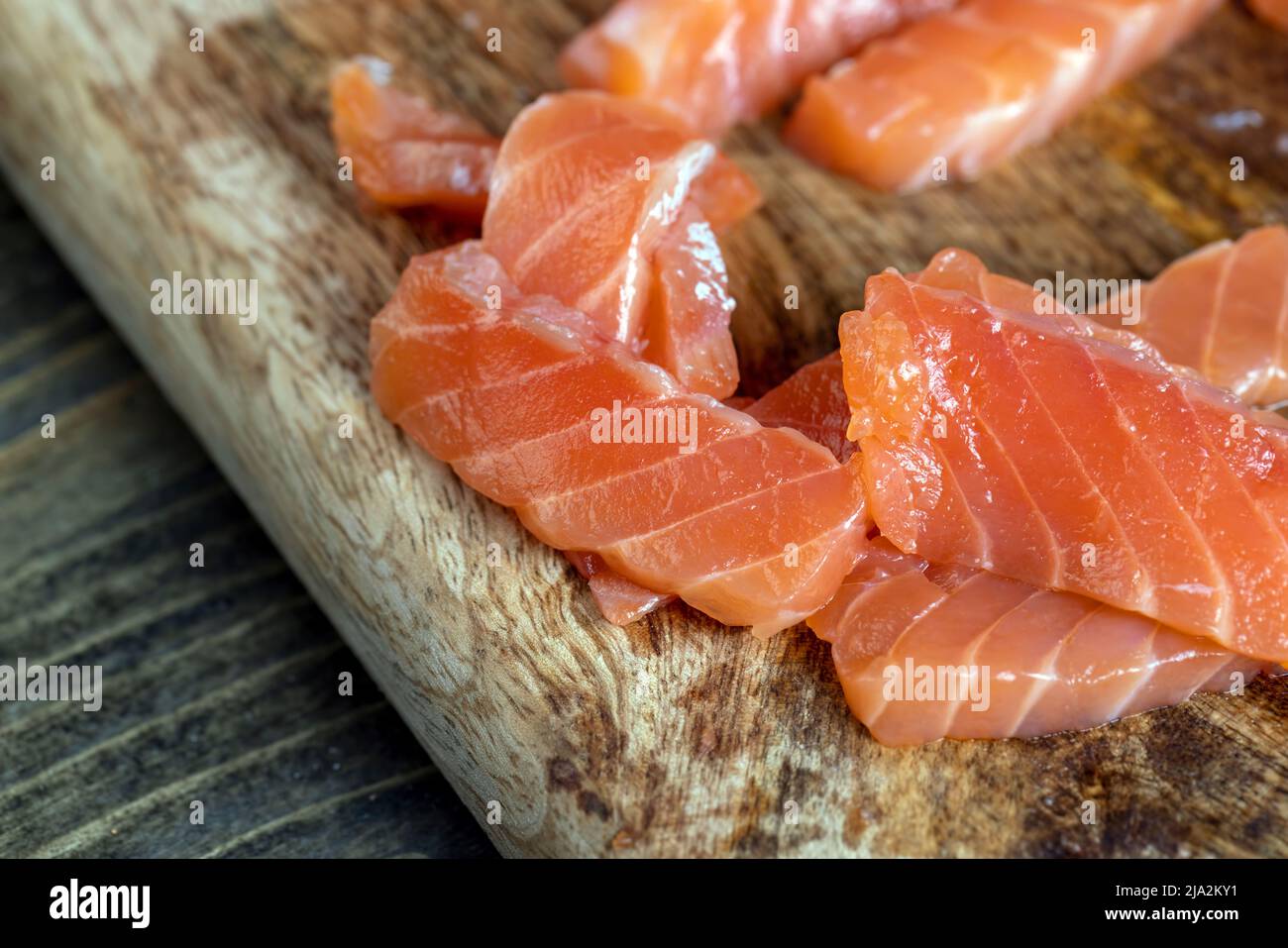 sliced red salted salmon during cooking, cutting fish fillets during ...