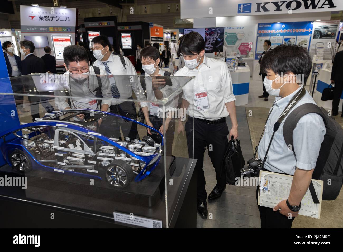Visitors take photos of a miniature car model at the exhibitor booth of ...