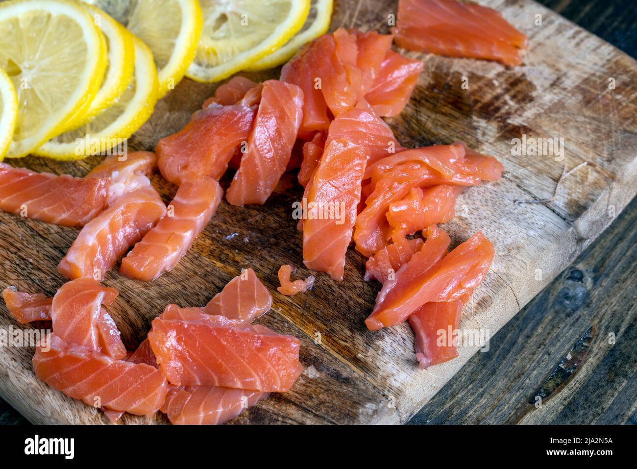 sliced red salted salmon during cooking, cutting fish fillets during ...