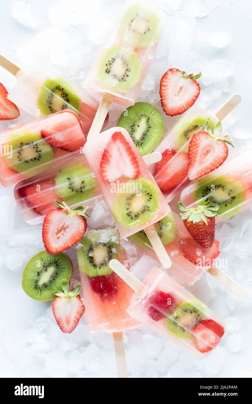 Refreshing strawberry kiwi popsicles in a pile on a bed of ice Stock ...
