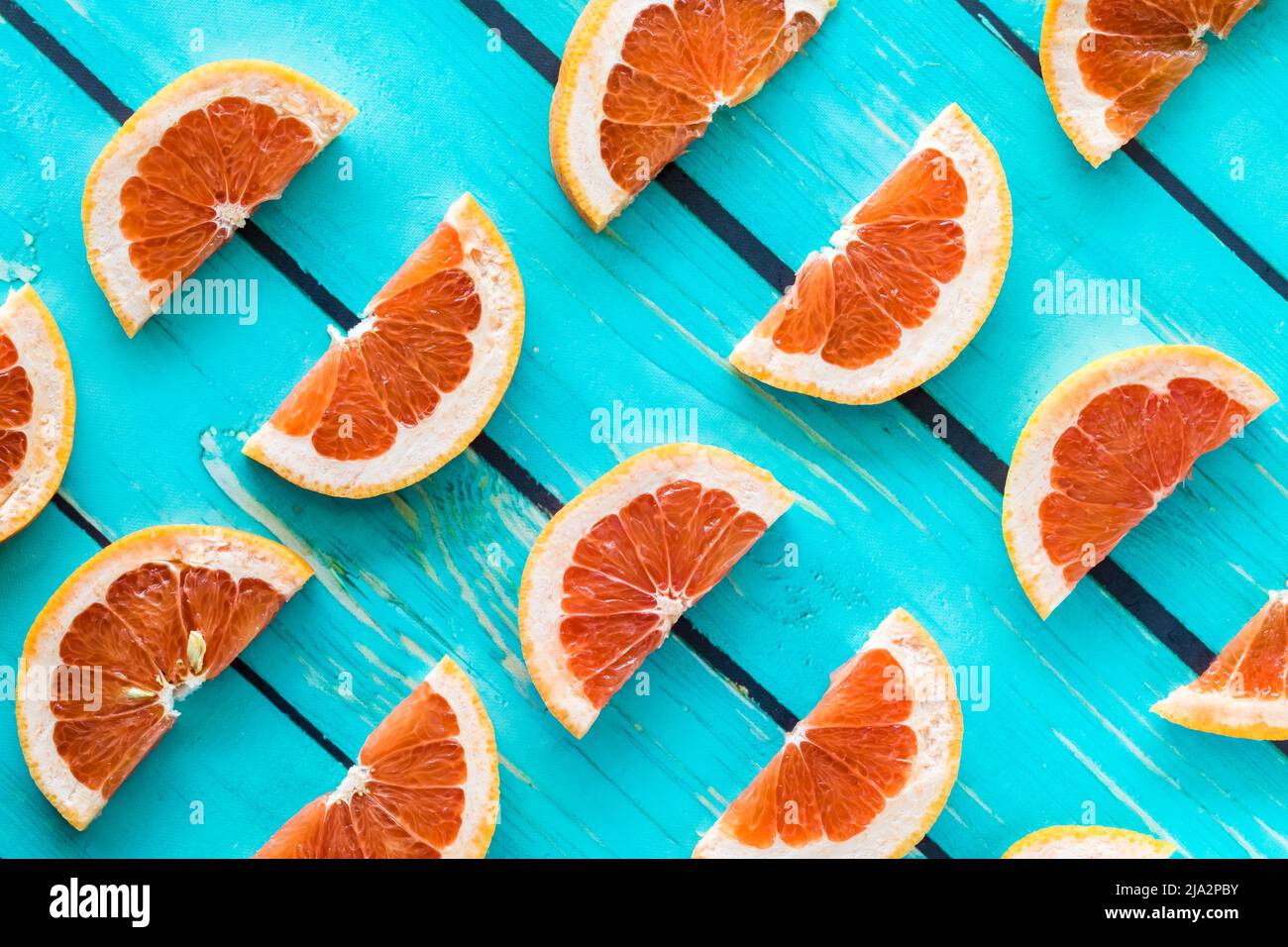 Slices of grapefruit in lines against a bright blue background Stock ...