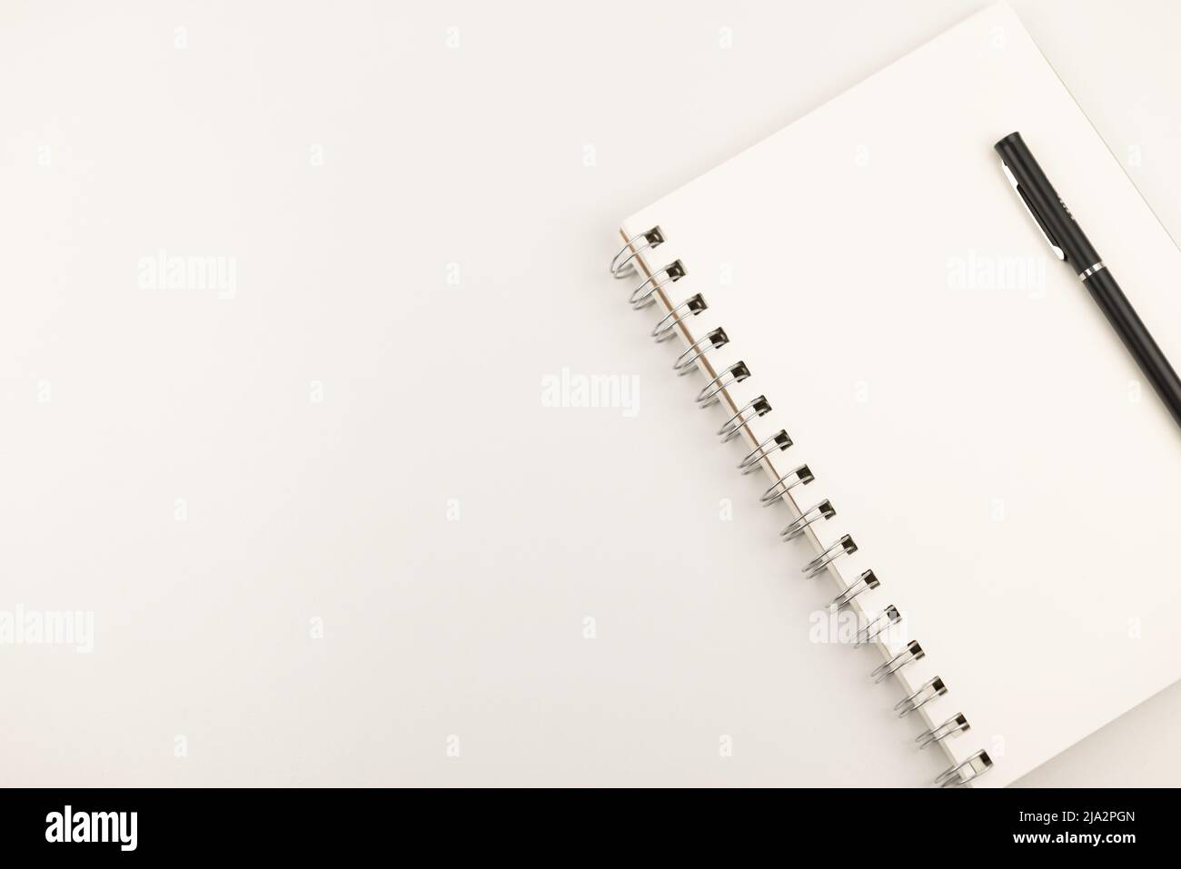 Simple flat lay white spiral notebook with black pen on white ...