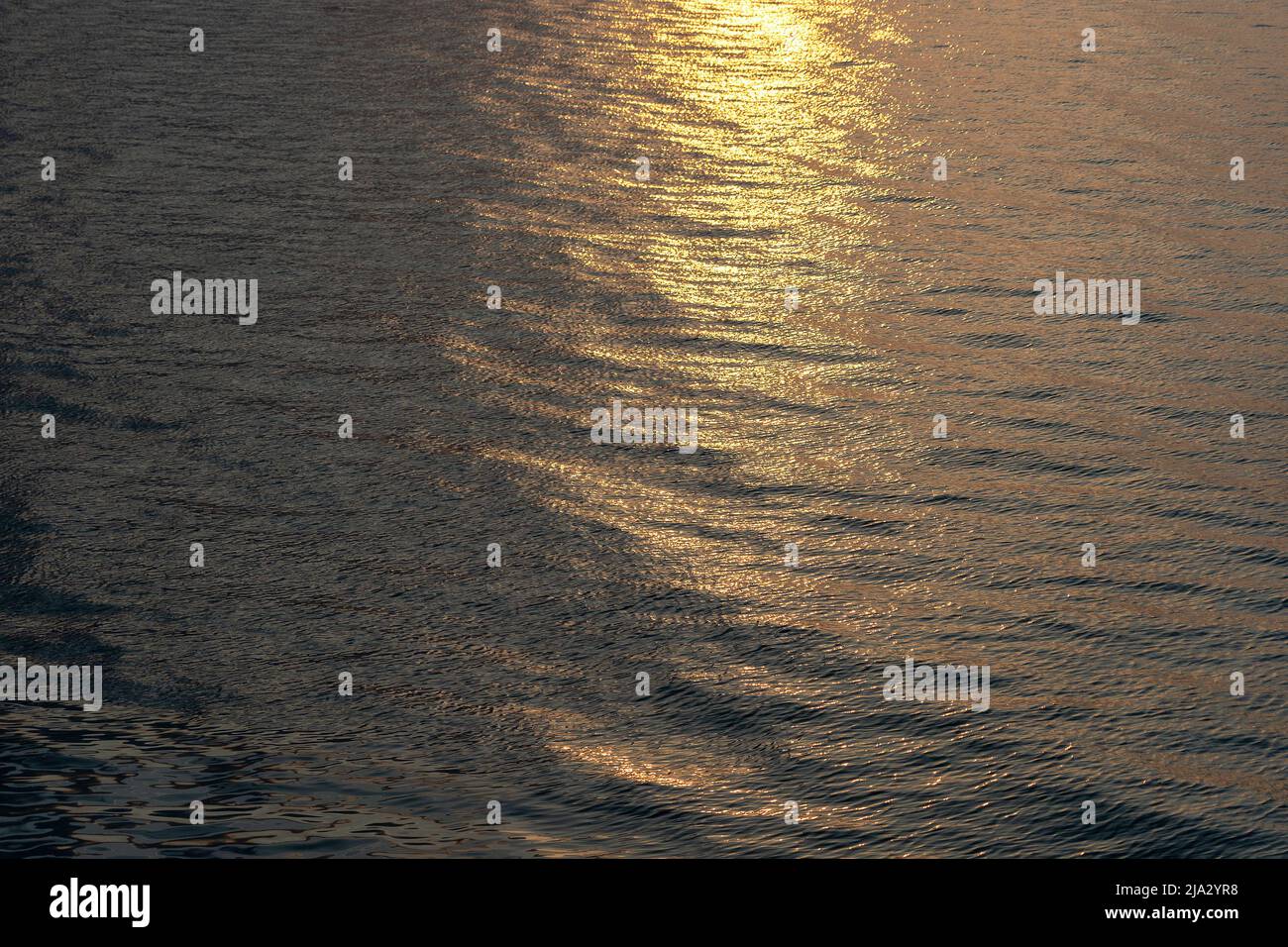 Beautiful sunset reflection sparkles on tiny ripples of sea water wave ...