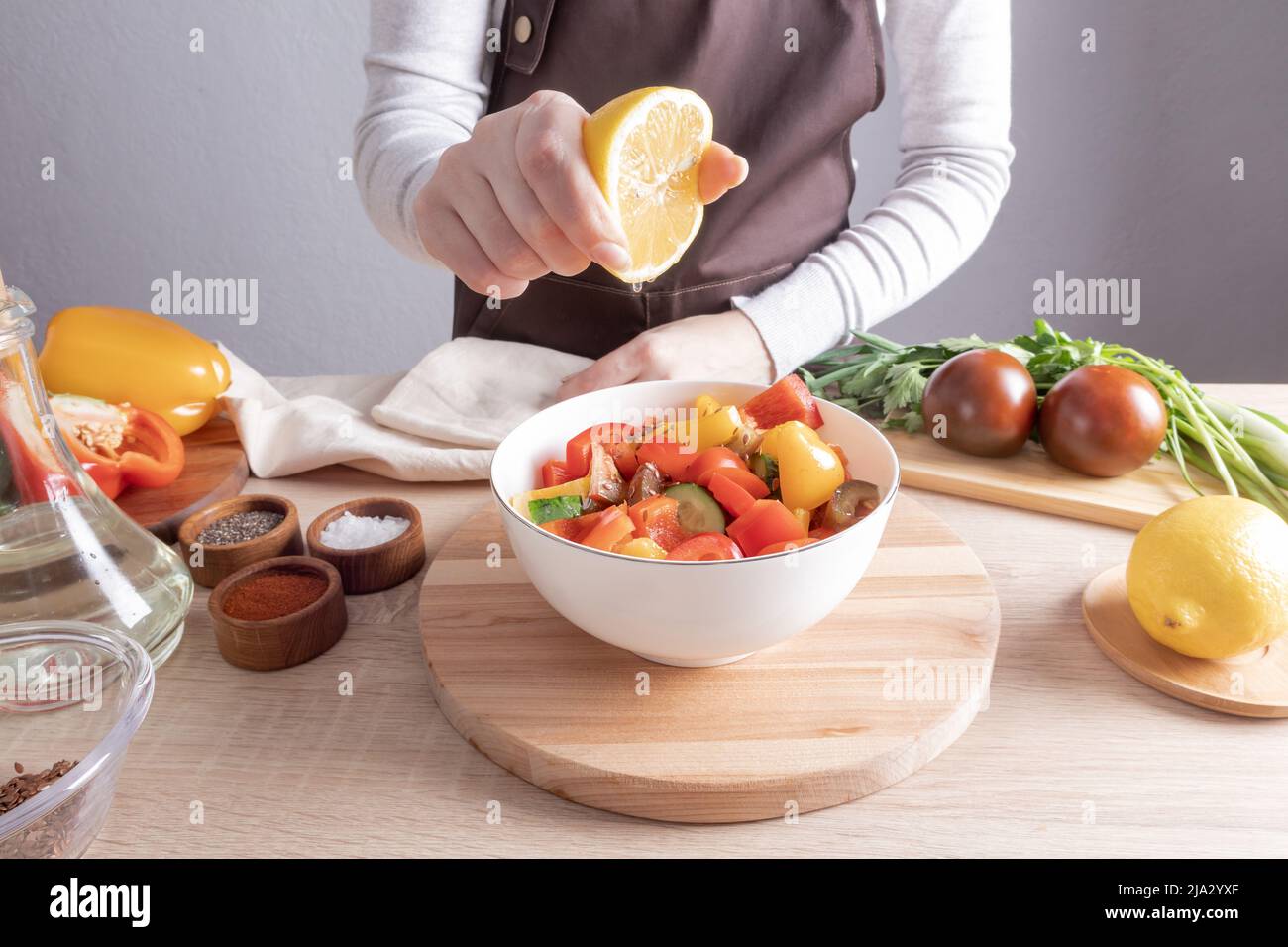 cooking dietary meals at home. a girl's hand squeezes lemon juice into ...