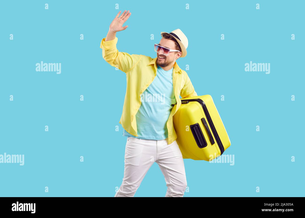 Happy man who is going on summer holiday is carrying his suitcase and ...