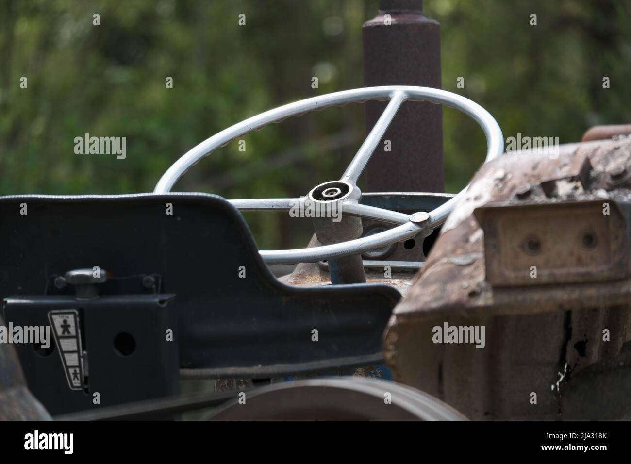 The steering wheel of an old tractor seen from close up. Side view with ...