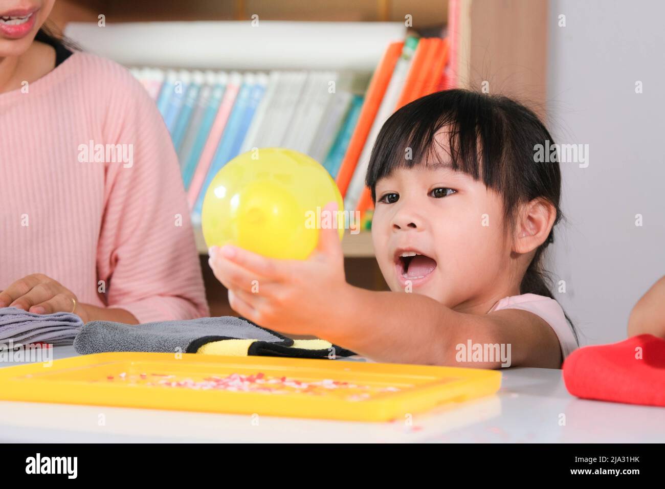 Little girl is learning and doing electrostatic science experiments ...