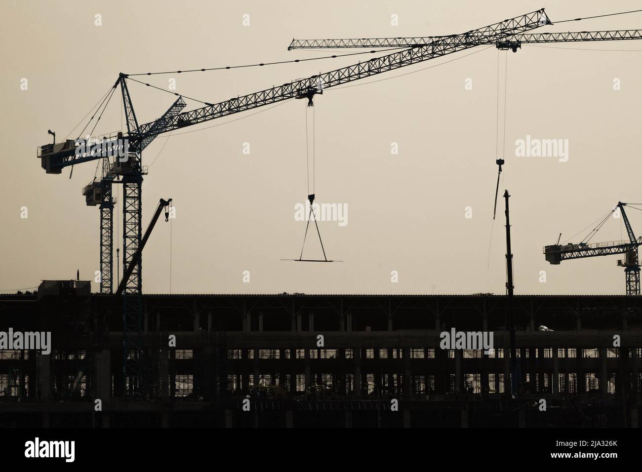 A large construction site with busy cranes. Tower cranes working on a ...