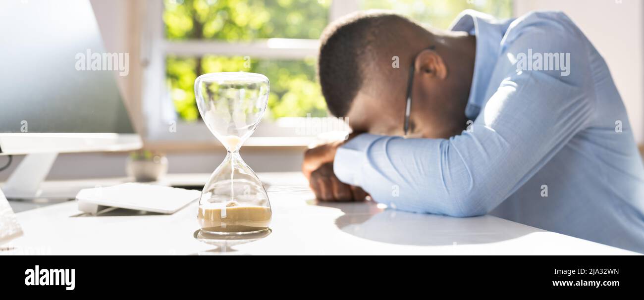 Exhausted Man Working In Office Under Time Pressure Stock Photo - Alamy
