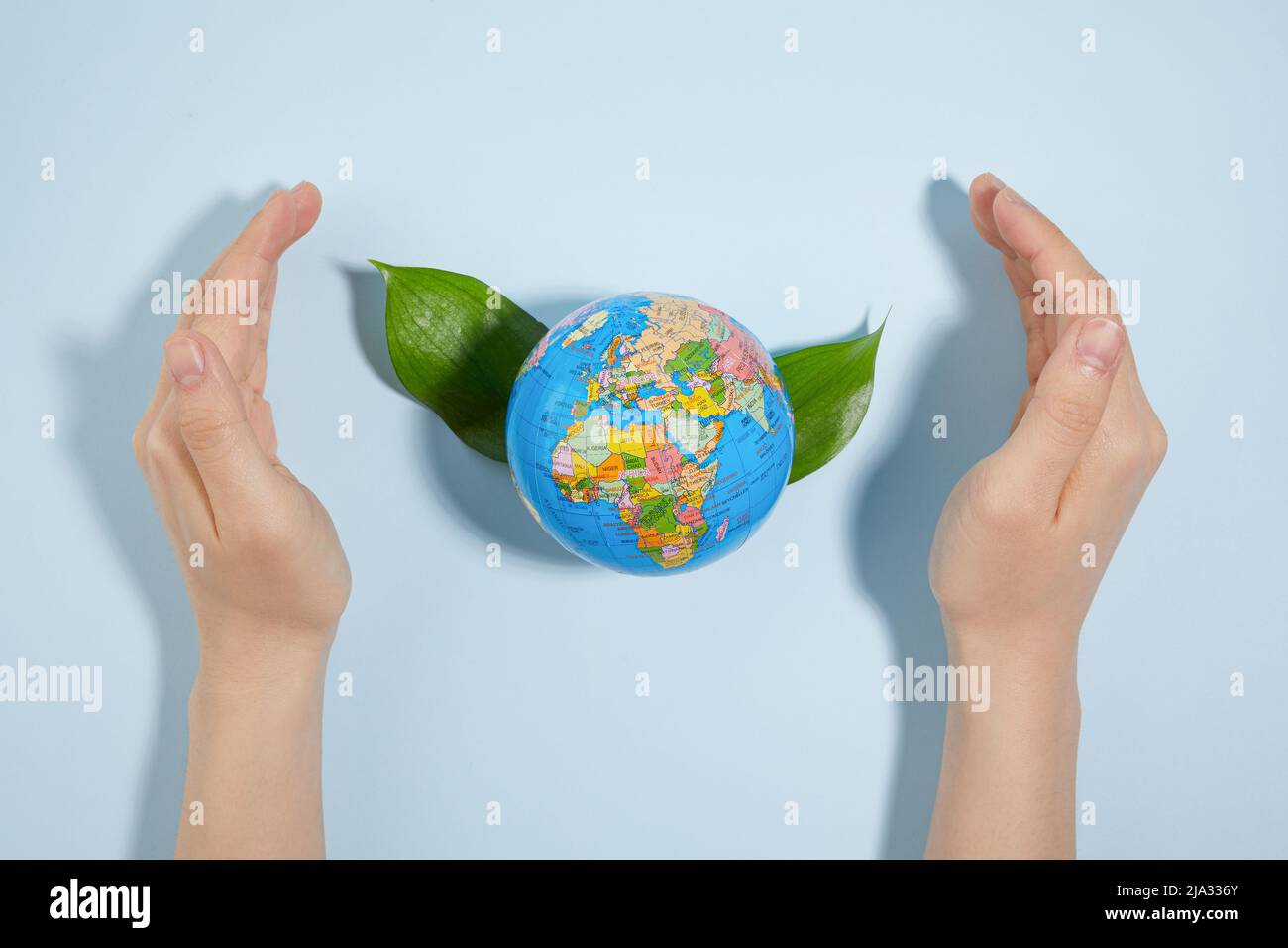 protect earth and environment concept, hand wrapped globe and leaves ...