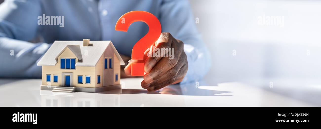 Man Holding Question Mark Next To House Model Stock Photo - Alamy