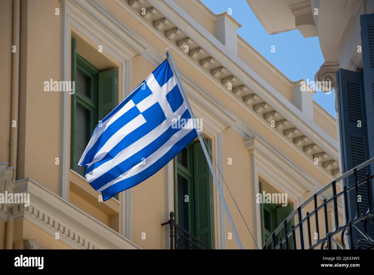 The Greek flag hangs from a balcony Stock Photo - Alamy