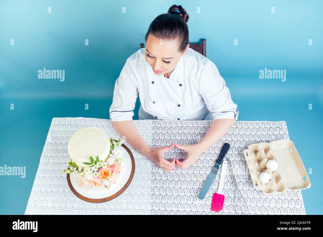 confectioner pastry chef woman shows fingers heart symbol next to ...