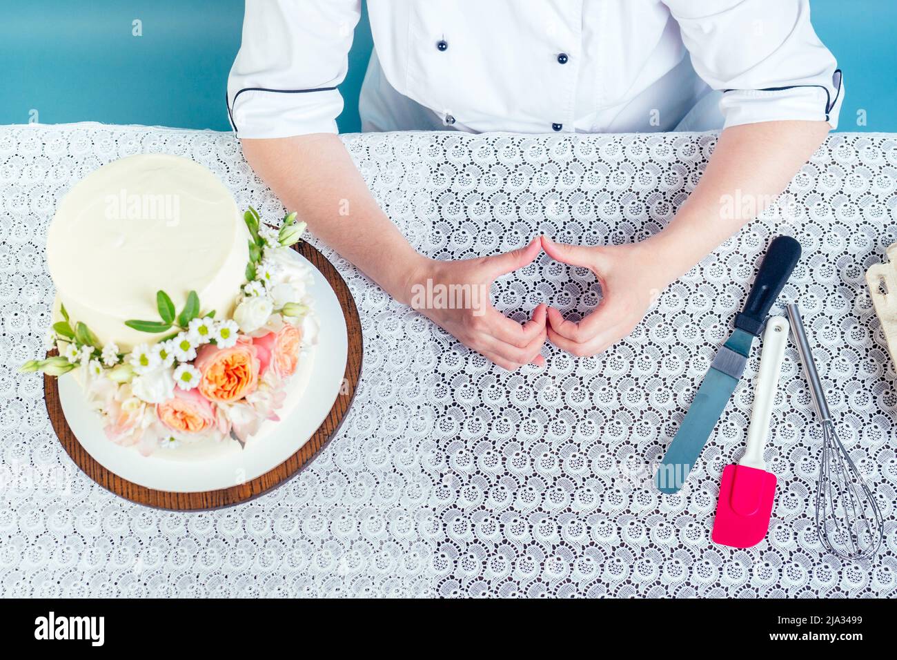 confectioner pastry chef woman shows fingers heart symbol next to ...