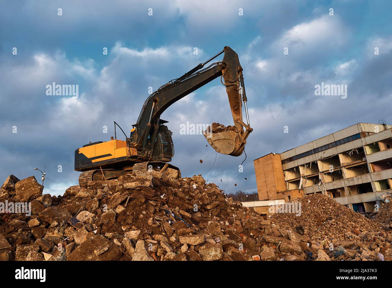 Building excavator on concrete pieces at demolition site Stock Photo ...
