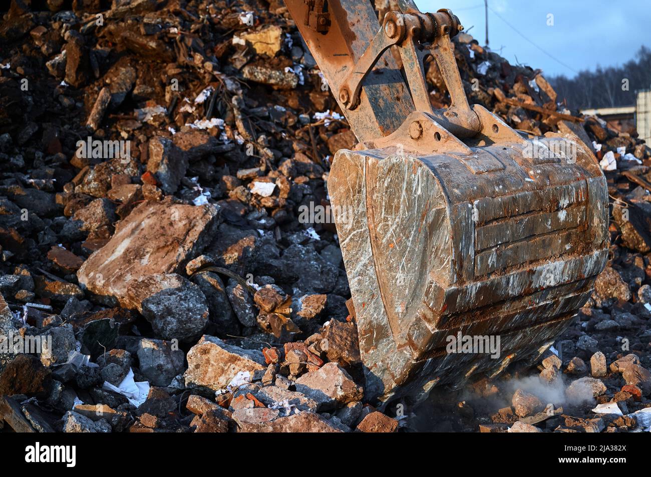 Bucket of excavator digs leftovers of destroyed building Stock Photo ...