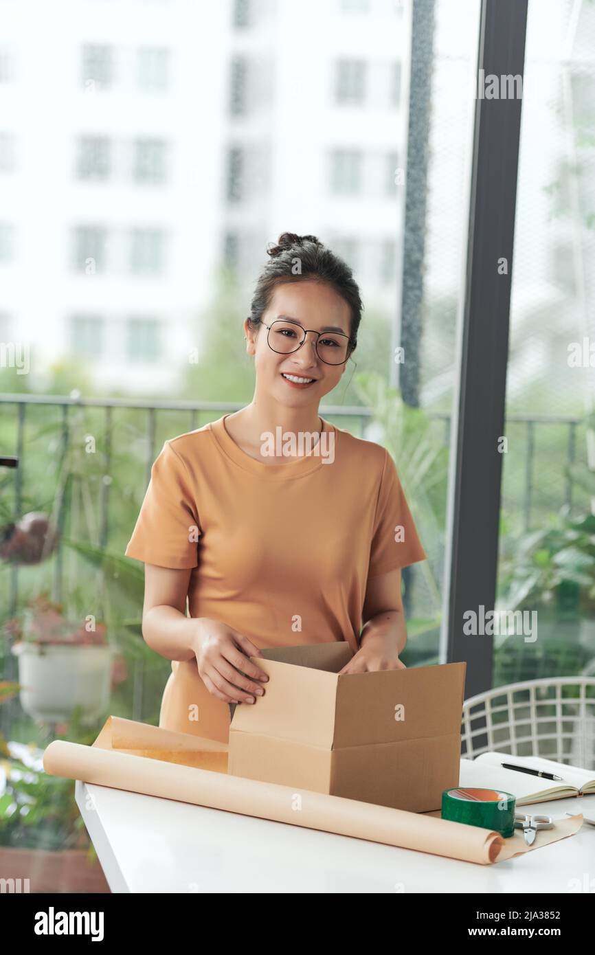 young start up small business owner packing cardboard box at workplace ...