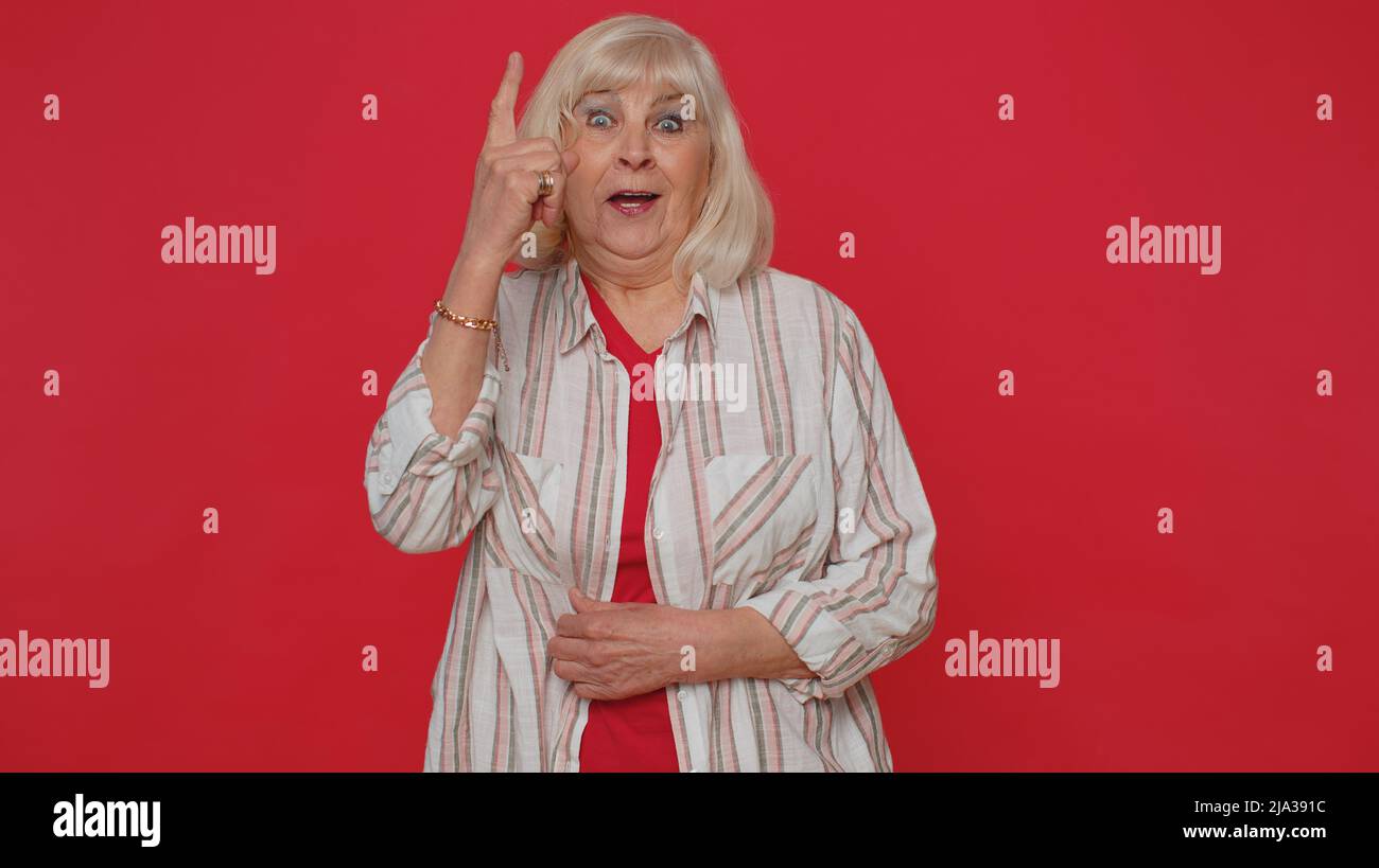 Inspired senior woman pointing finger up, showing Eureka gesture ...